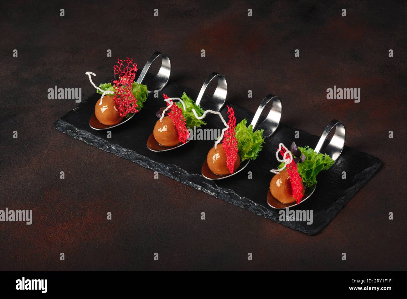 Molecular modern cuisine galantine duck in spoons on stone and rusty ...