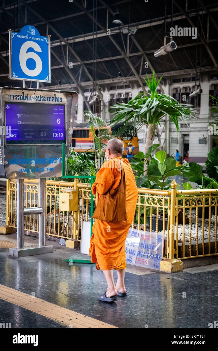 A Thai monk makes his way along the train platform at Hua Lamphong ...