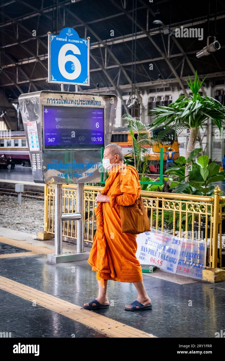 A Thai monk makes his way along the train platform at Hua Lamphong ...