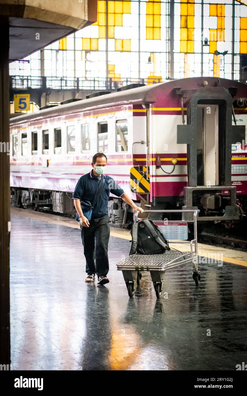 A porter pushes a baggage trolley the train platform at Hua Lamphong ...