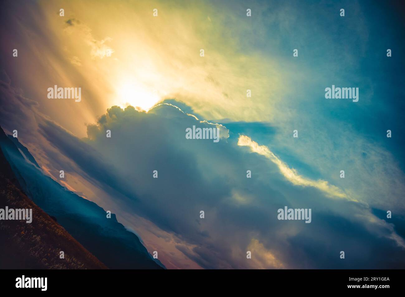Sun hide behind the clods top of the mountain peak Stock Photo - Alamy