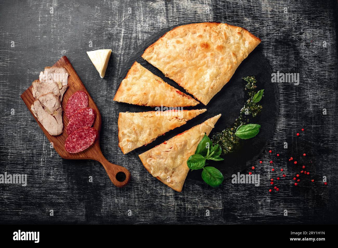 Traditional Italian pizza calzone with ingredients on a stone and dark ...