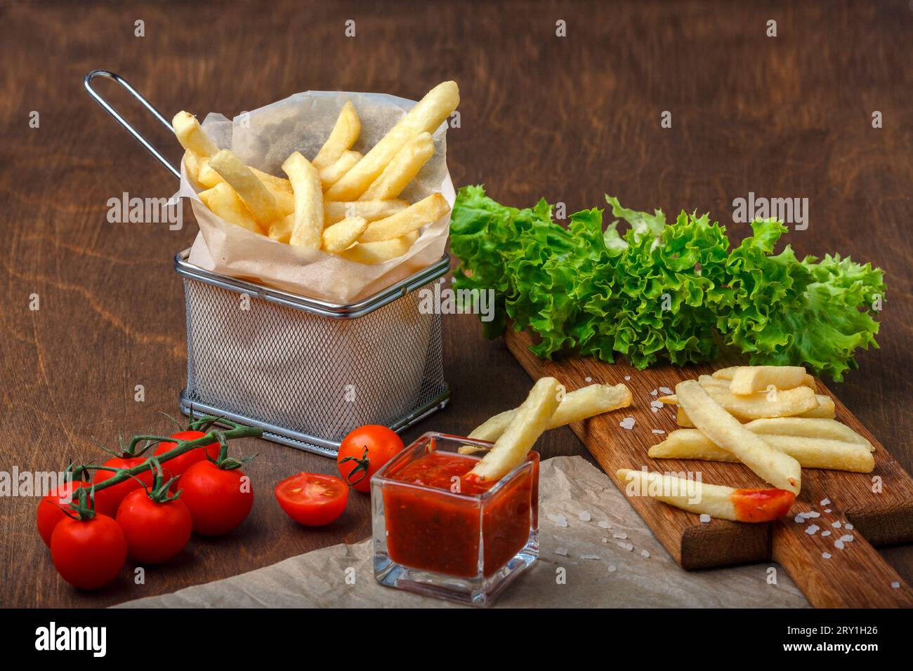 French fries in a grid with ketchup, salad and cherry tomatoes on ...