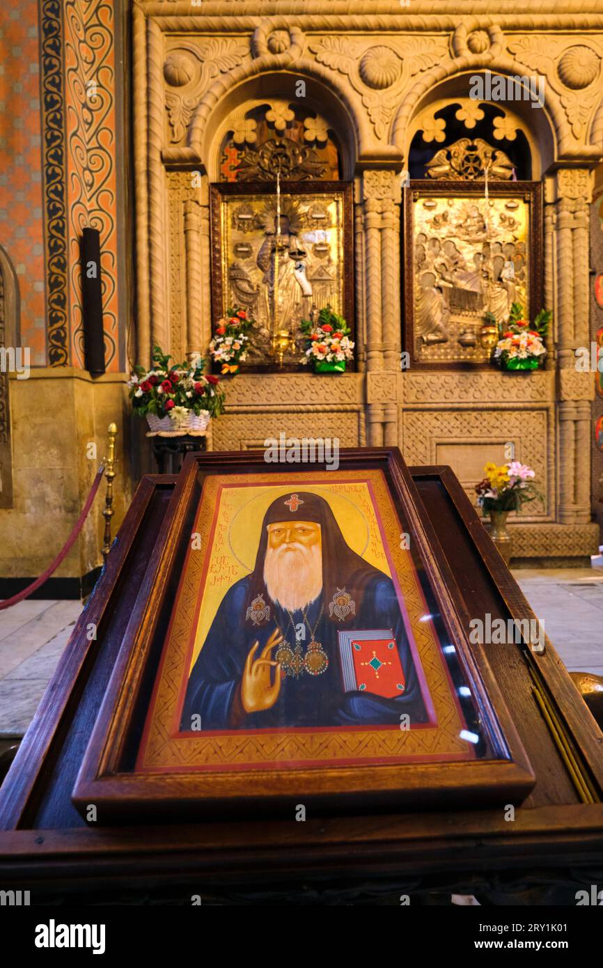 A gold icon painting of an old priest with long, white beard. At the ...
