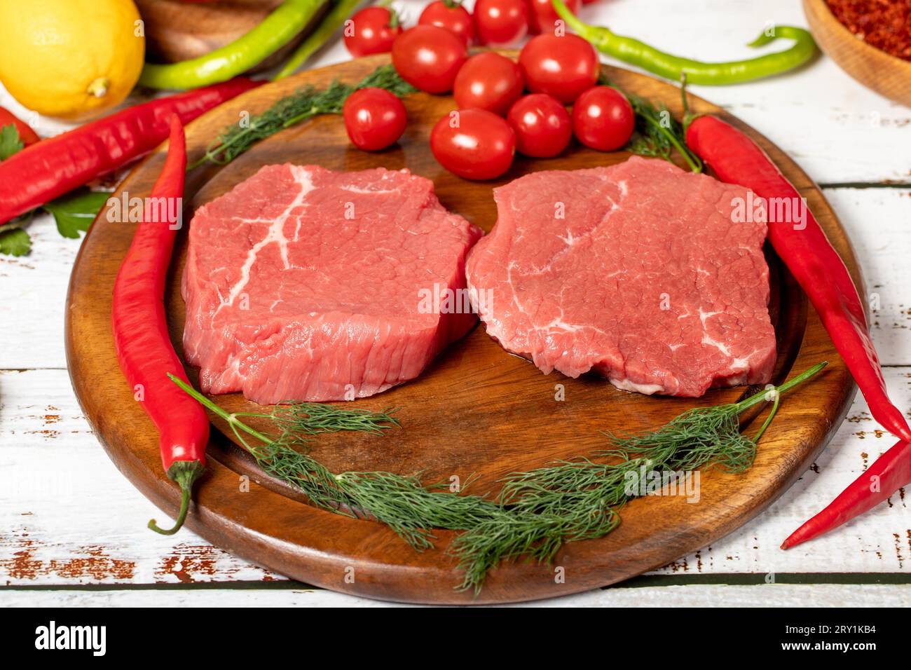 Beef round slice on wood background. Raw beef round with herbs and ...