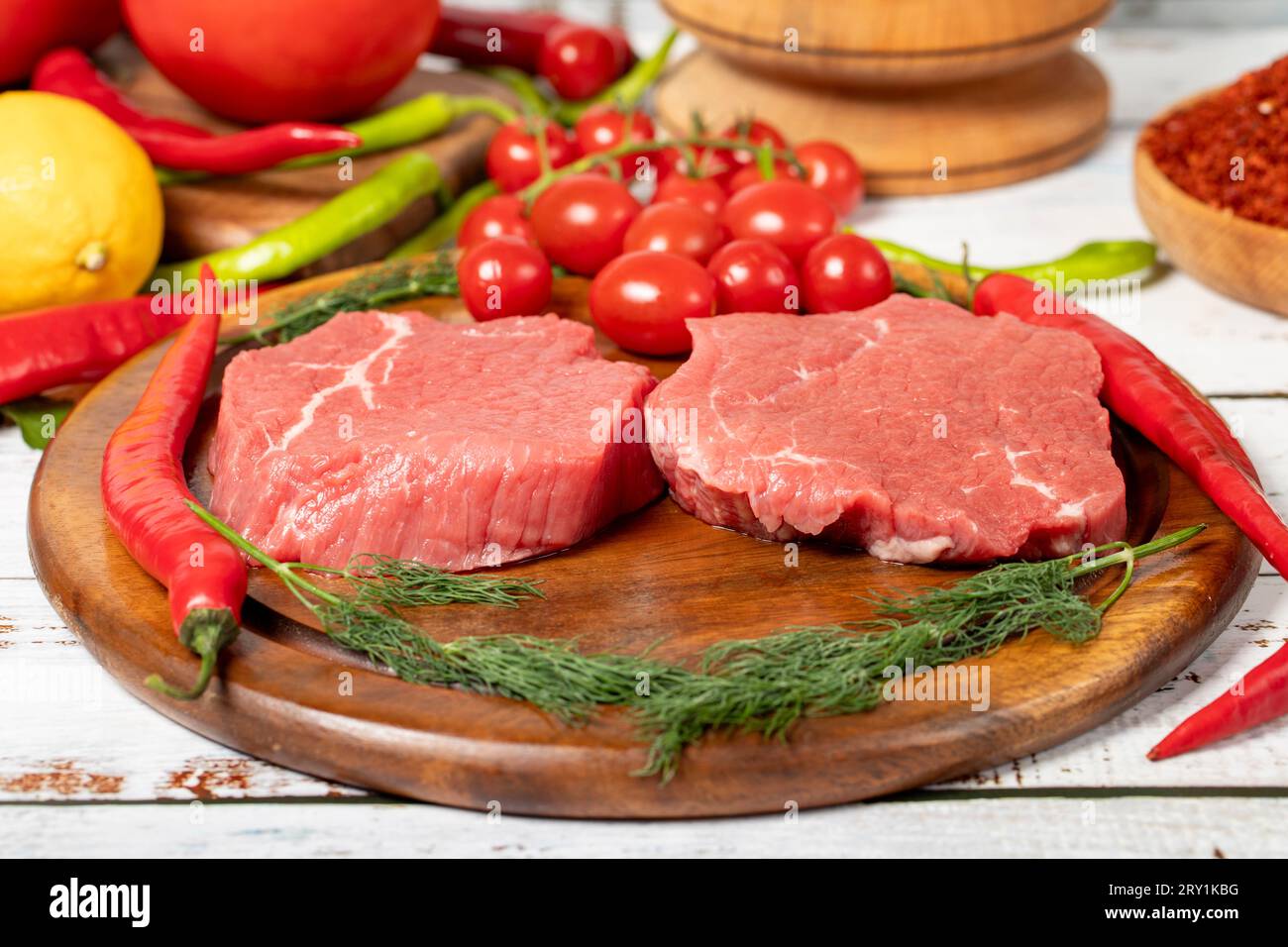 Beef round slice on wood background. Raw beef round with herbs and ...