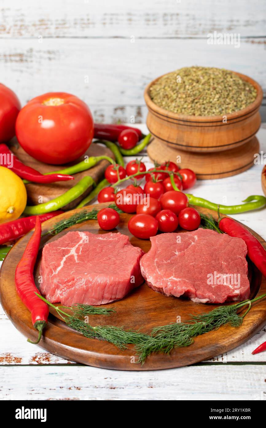 Beef round slice on wood background. Raw beef round with herbs and ...