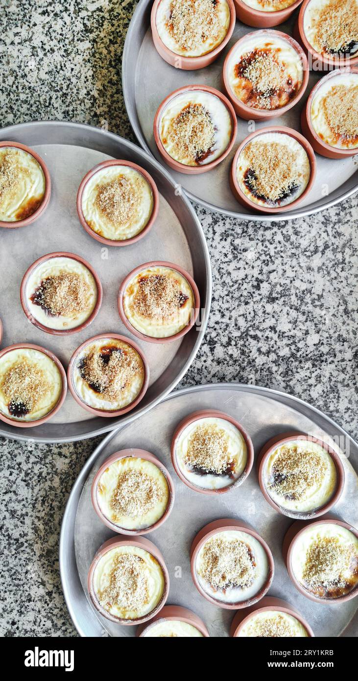Plates with Turkish rice pudding Syutlach stand on round metal trays ...