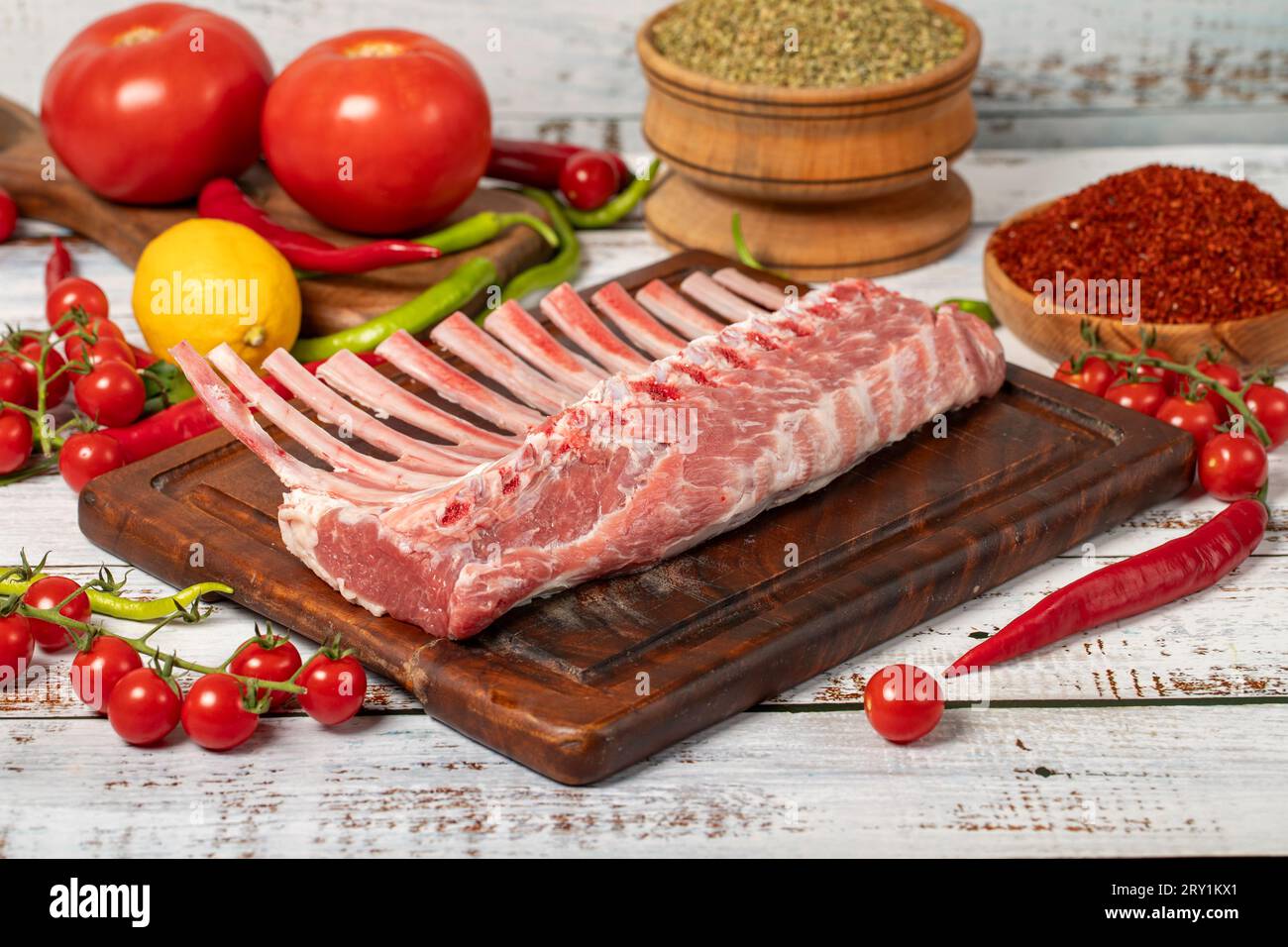 Lamb rack cutlet on wood background. Raw lamb chops with herbs and ...