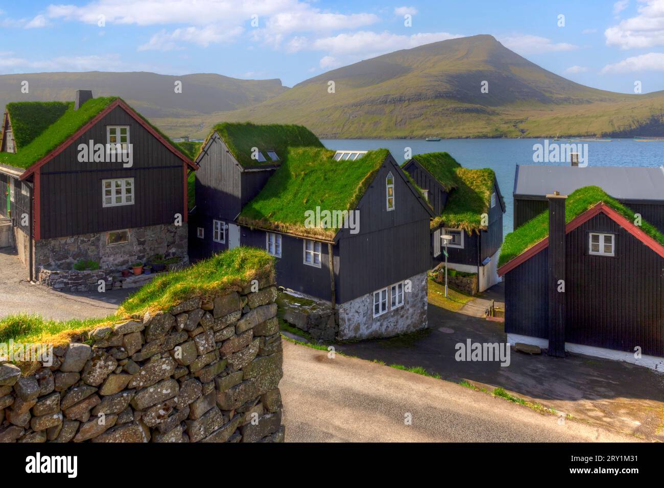 Turfed Houses and sea stack Tindholmur in Bour, Faroe Islands Stock ...