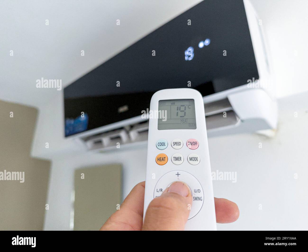 Air conditioner. Temperature adjustment by remote control at 19°C Stock ...