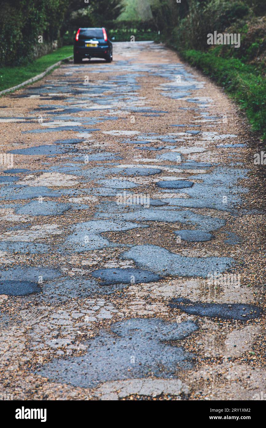 . English road with potholes and bitumen repair Stock Photo - Alamy