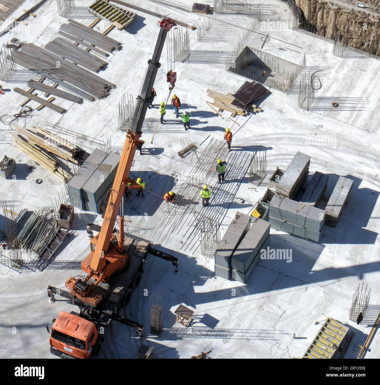 Workers in orange and yellow uniform working with reinforcement and ...