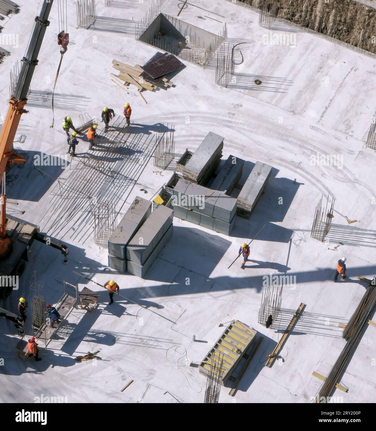 Workers in orange and yellow uniform working with reinforcement and ...