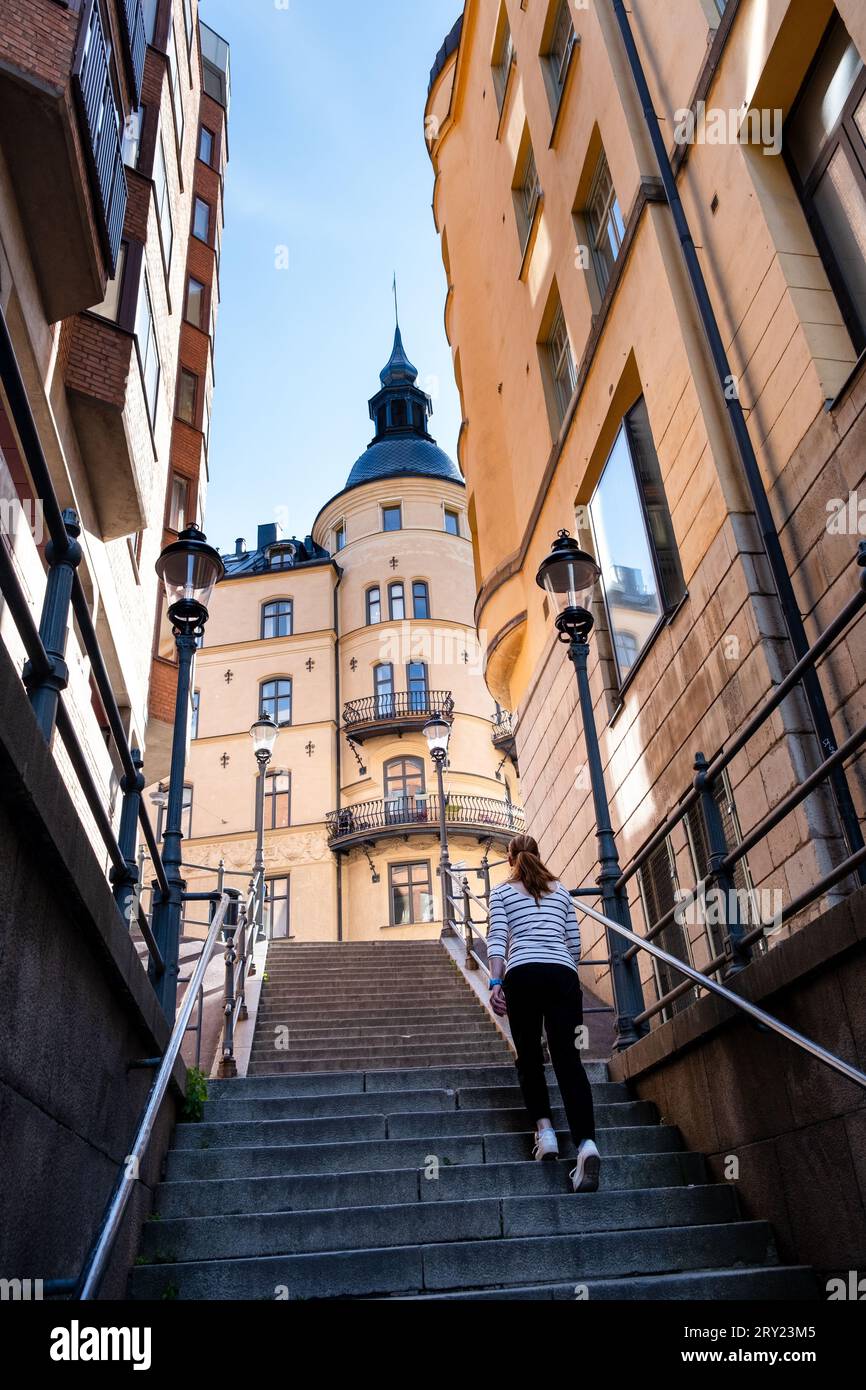 A woman climbing steps linking different levels on a typical street in ...