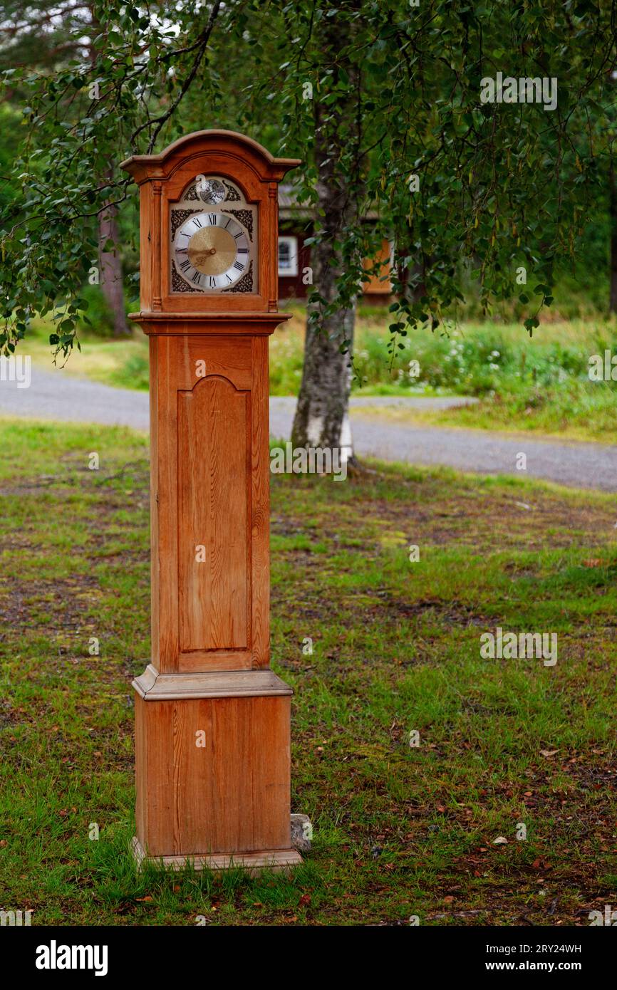 an old floor clock in the middle of nature Stock Photo - Alamy