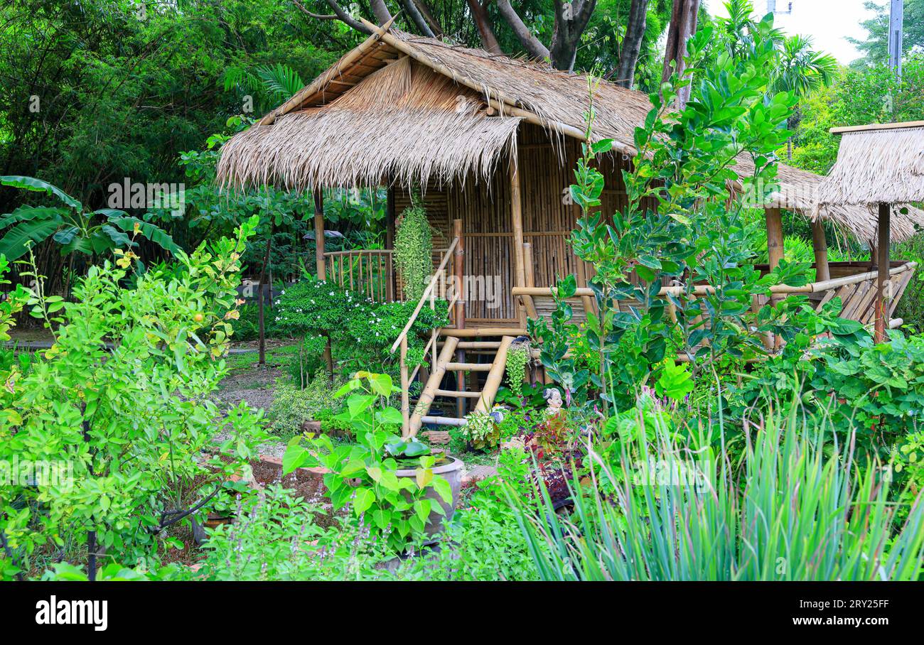 Nice wooden hut in a green garden. flowers and tree in front of a ...