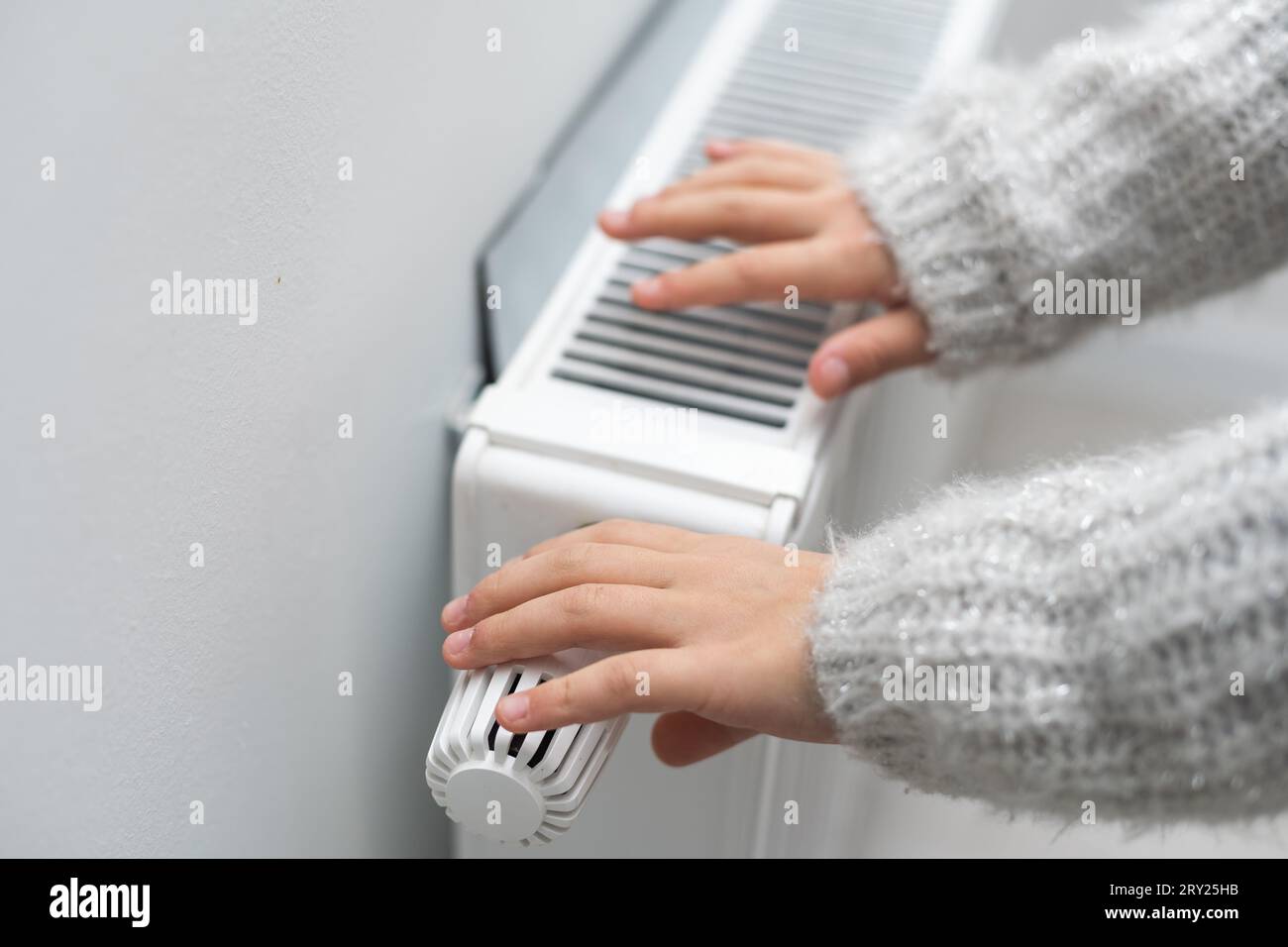 Children's hands warm on the radiator Stock Photo - Alamy