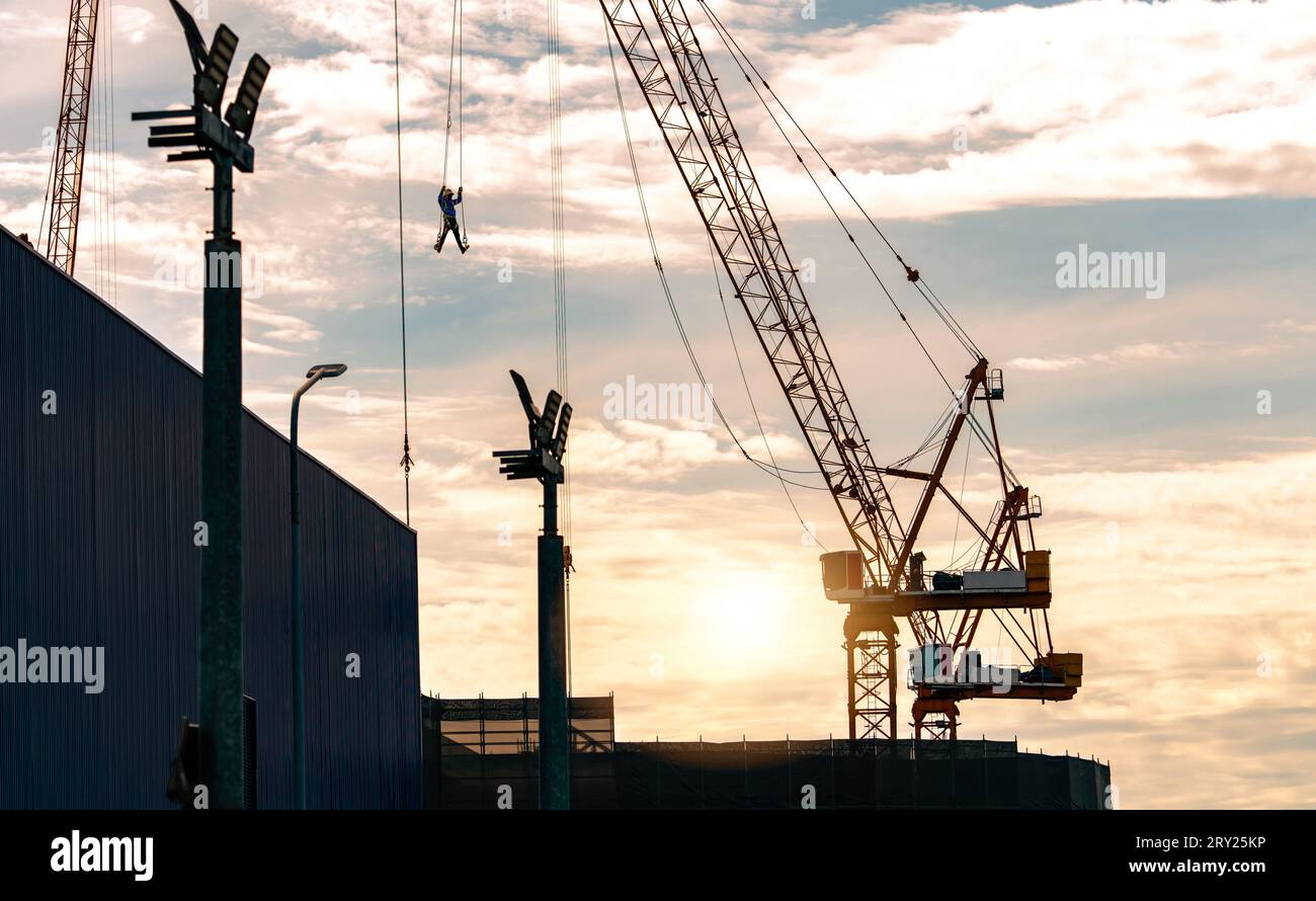 Silhouette construction crane working at construction site against ...