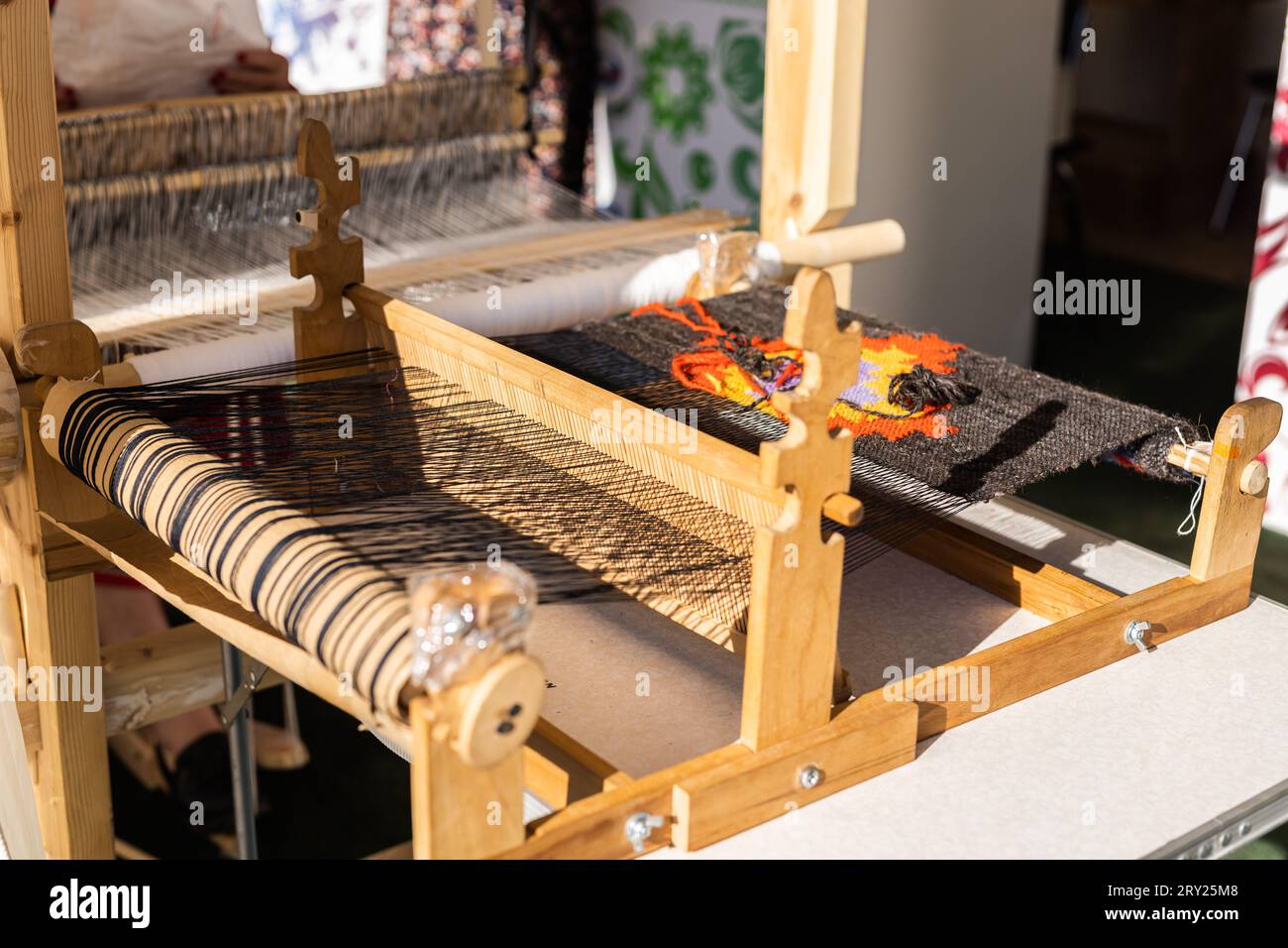 Handloom with wooden shuttle with mottled thread and bobbins of yarn ...