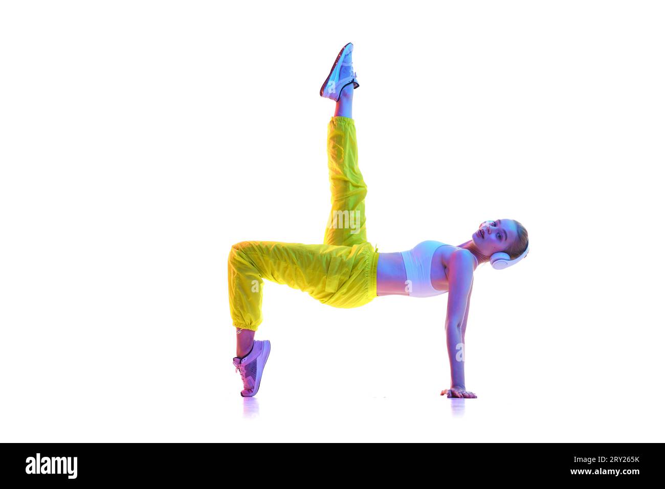 Side view portrait of young girl stand in table pose raise one leg in ...