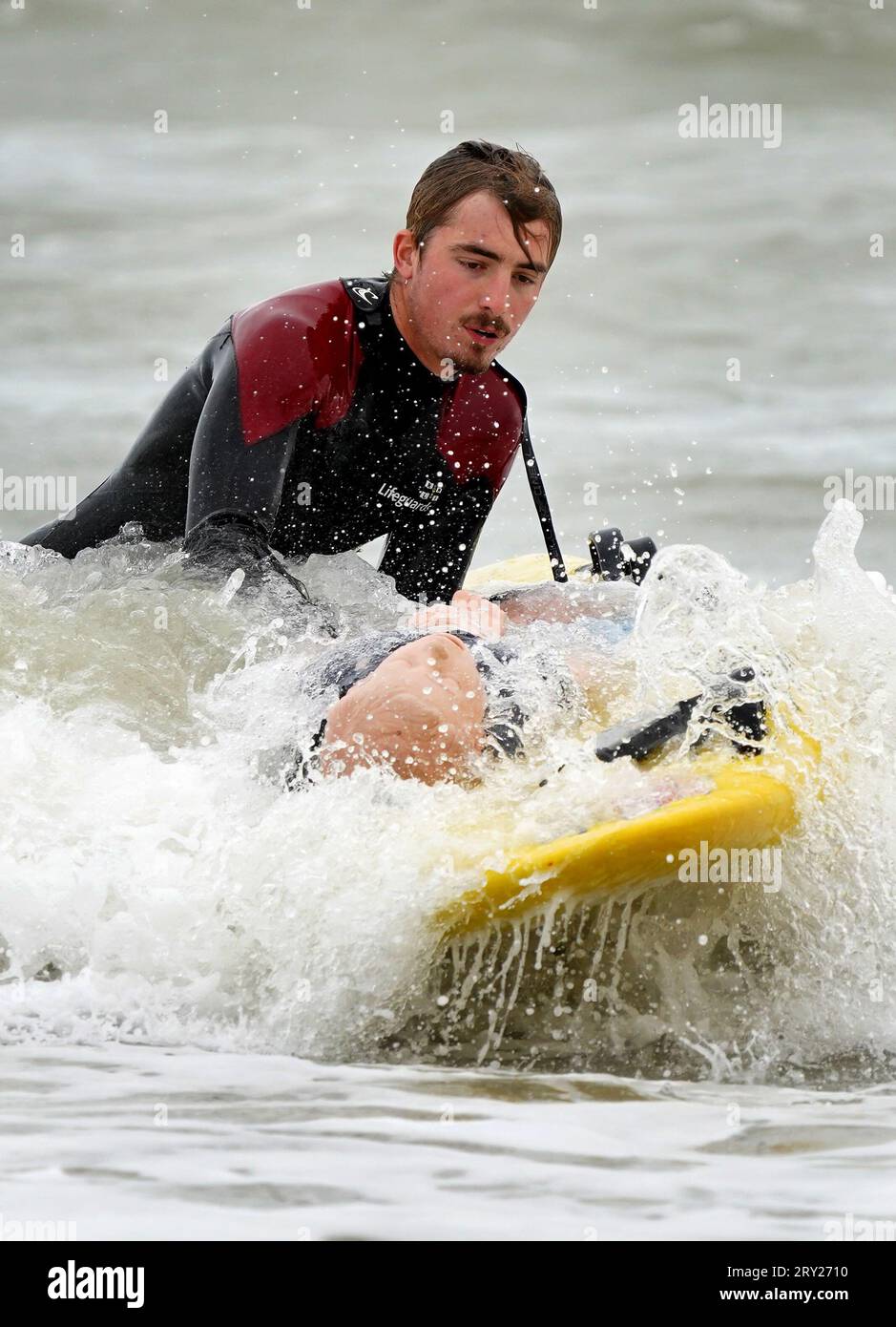 An RNLI Lifeguard rescues a dummy of a child from the sea during a ...
