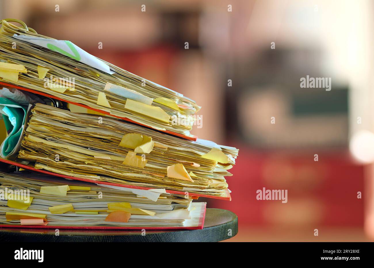 stack of dusty messy file folders with narrow depth of field, blurred ...