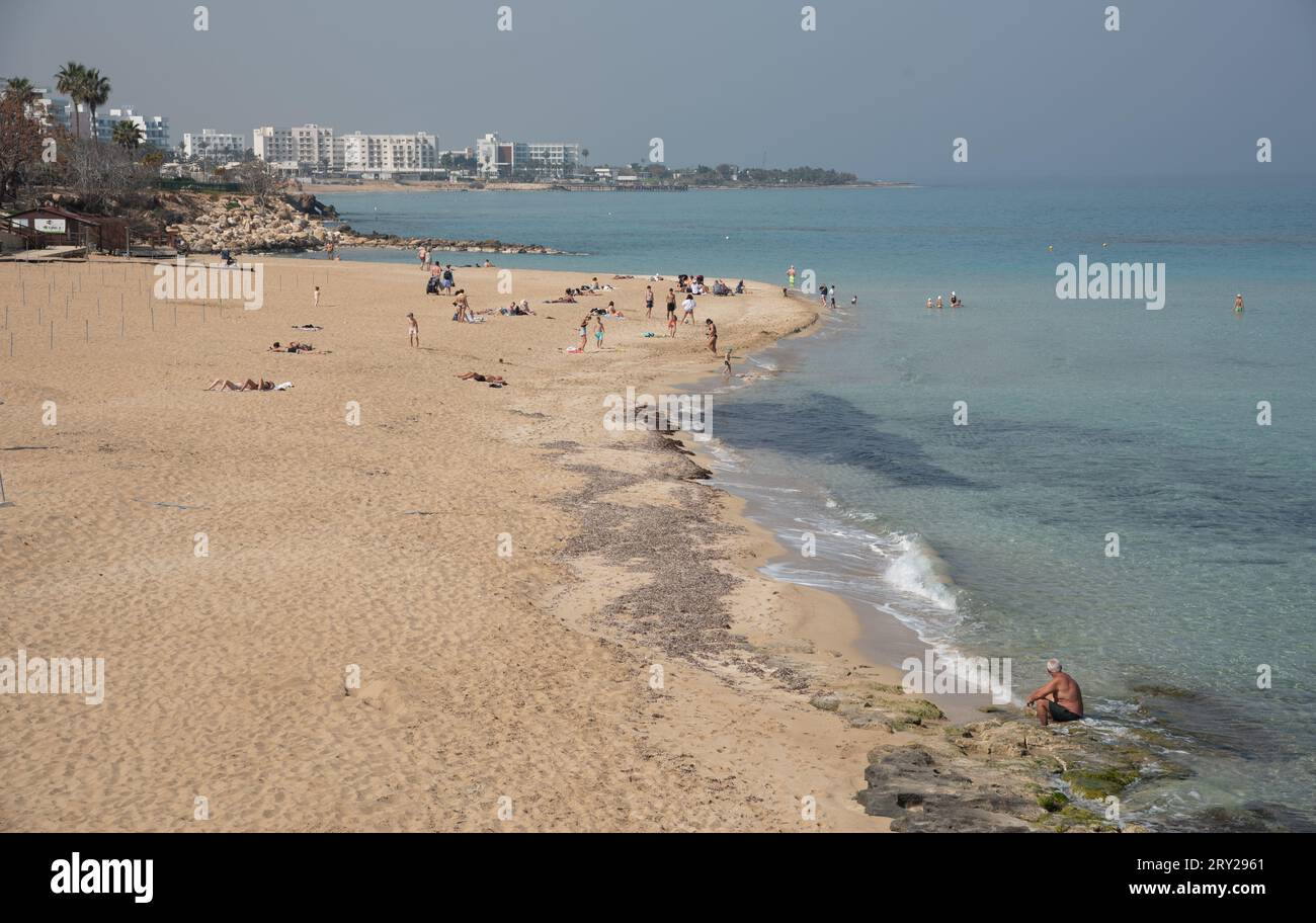 Tourist people enjoying the sandy beach relaxing, sunbathe snd swimming ...