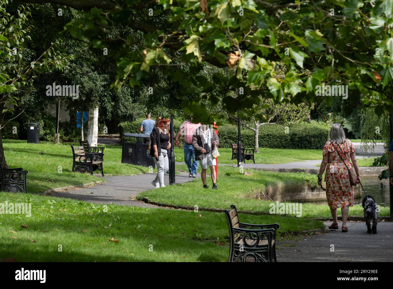 People enjoying a stroll walk through Trenance Gardens in Newquay in ...