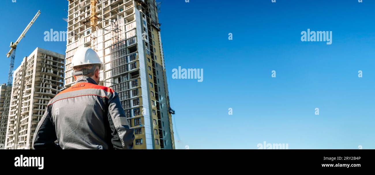 Builder at a construction site banner background. Construction of a ...