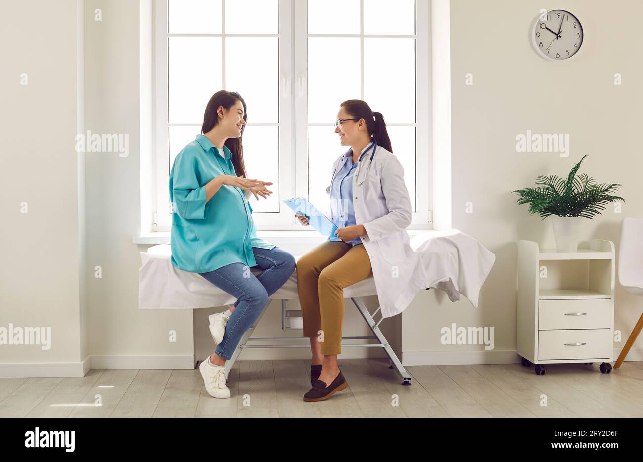 Smiling happy pregnant woman visiting her obstetrician doctor in ...