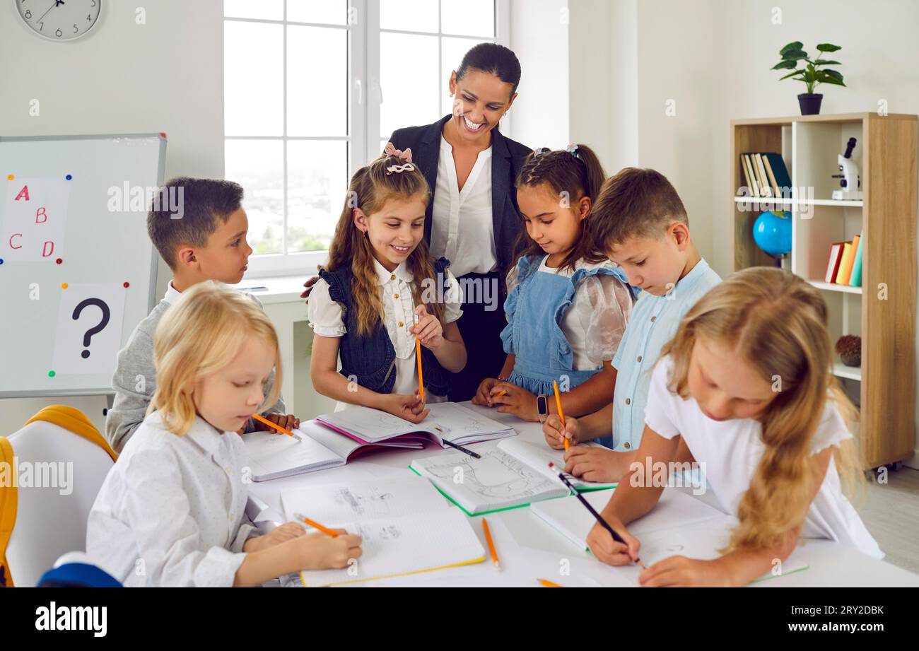 Group of happy kids do teachers task together. Schoolchildren write and ...