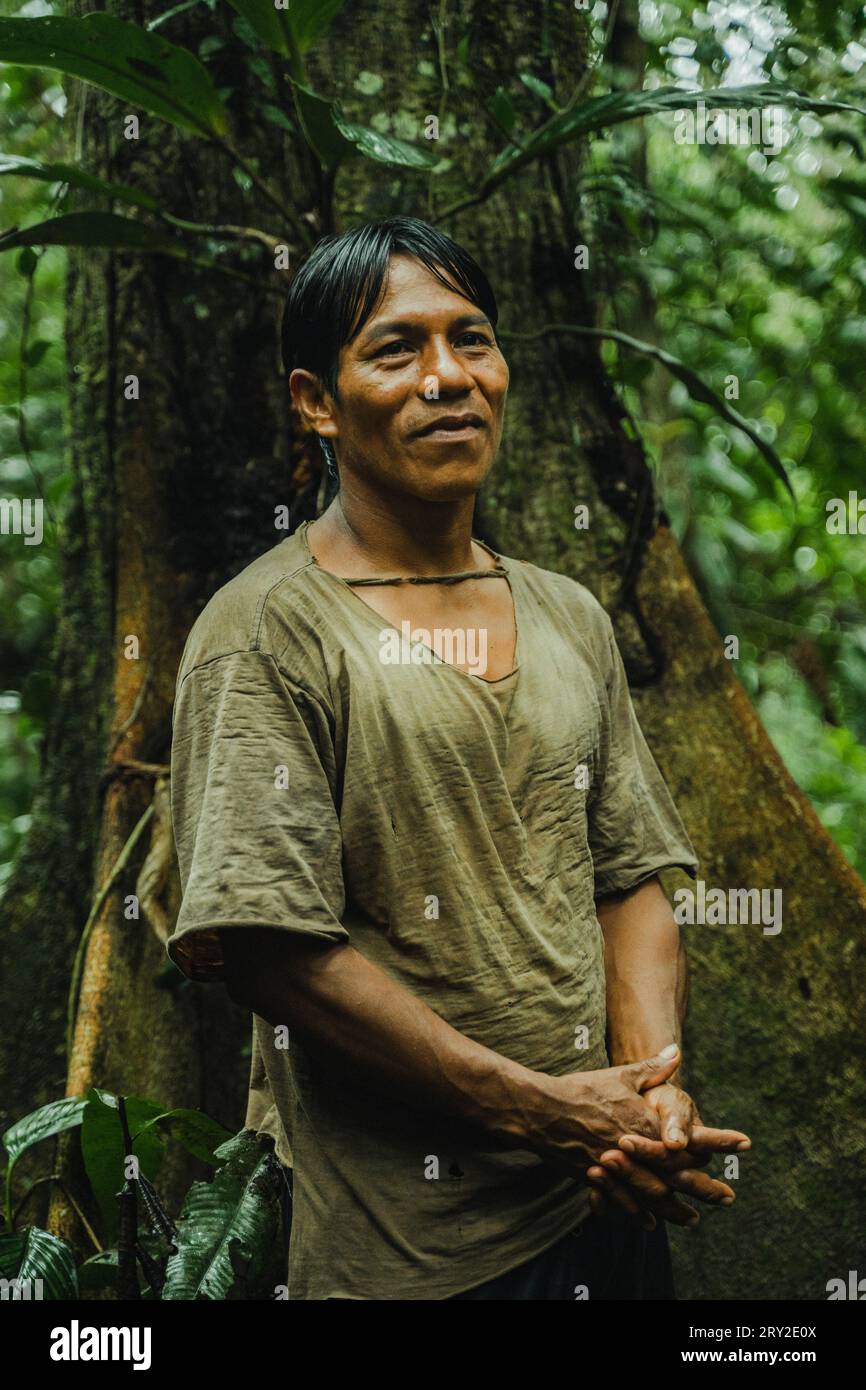 Happy ethnic male of tribe standing in green tropical forest and ...