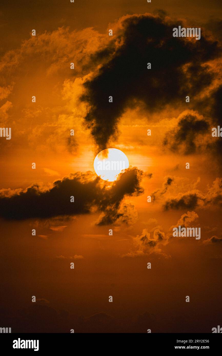 Picturesque view of rippling sea with colorful sundown with bright sun ...