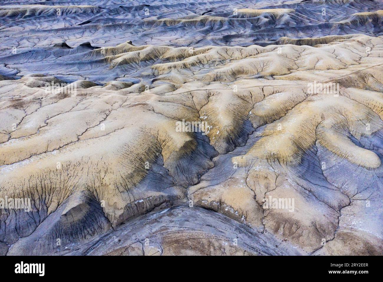 Aerial view of rough rocky mountains with river meandering through dry ...