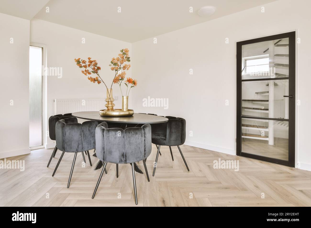 Interior of stylish modern dining room with flower vases on round table ...