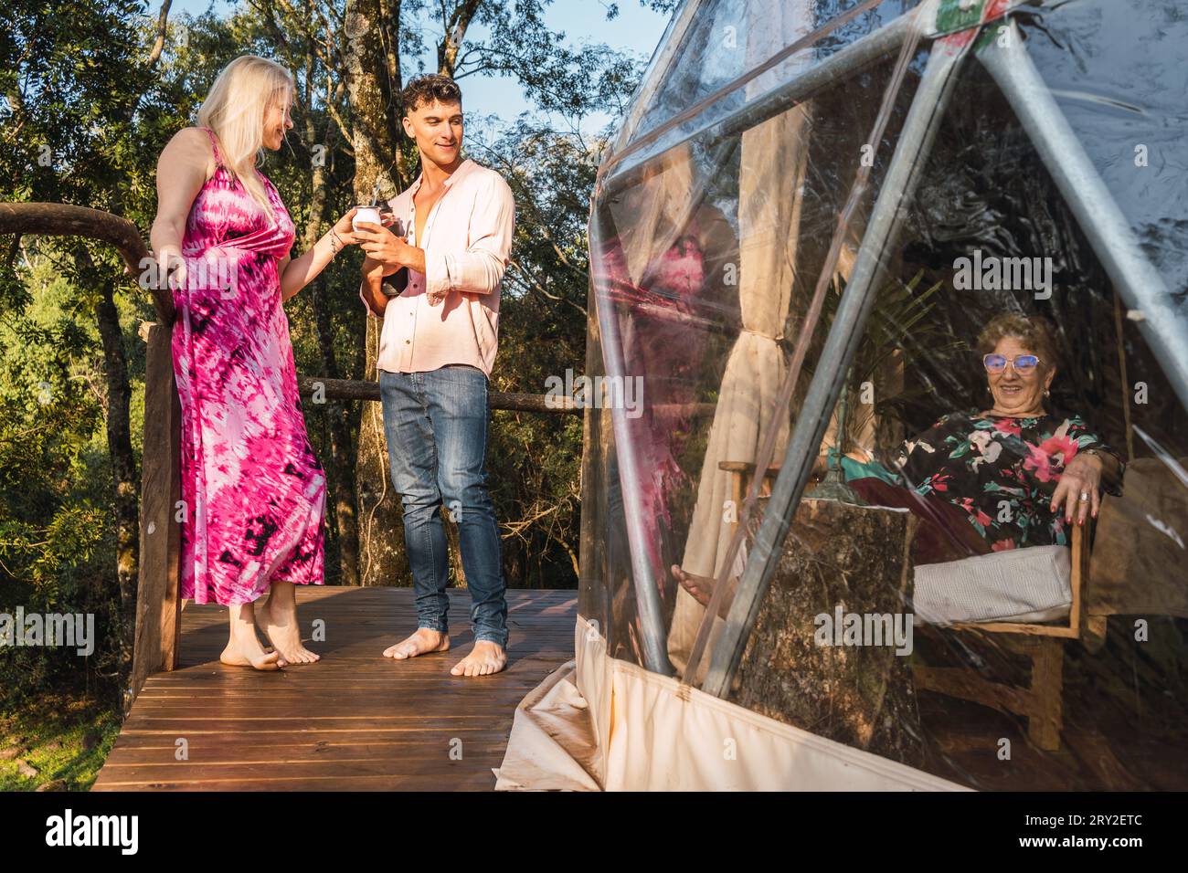 Full body of couple having tea on terrace while retired mother sitting ...