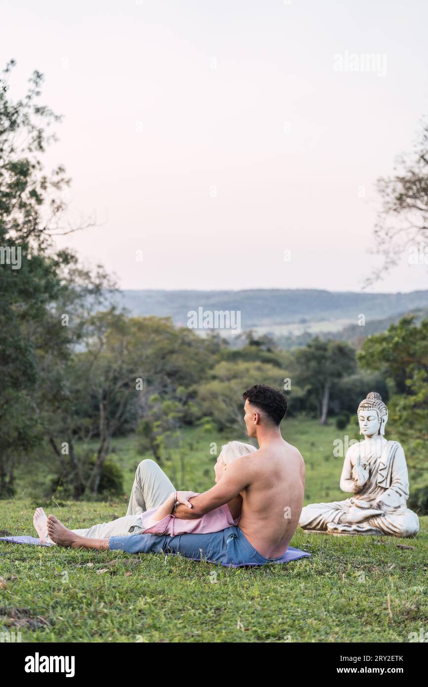Full body of male and female resting on blanket near Buddha statue and ...