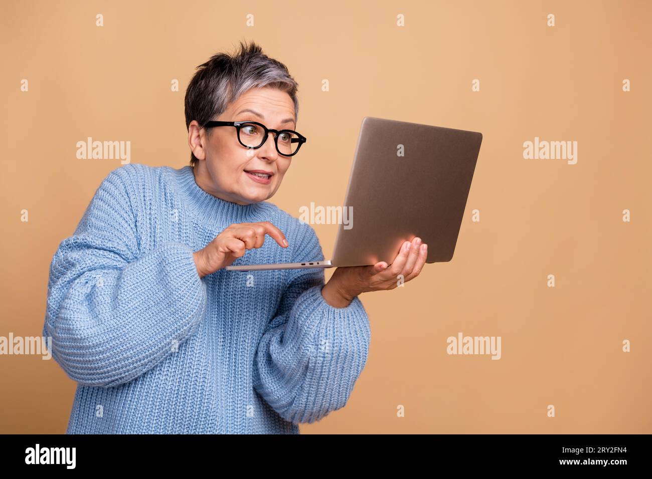 Photo of aged lady hold wireless netbook finger press button write ...