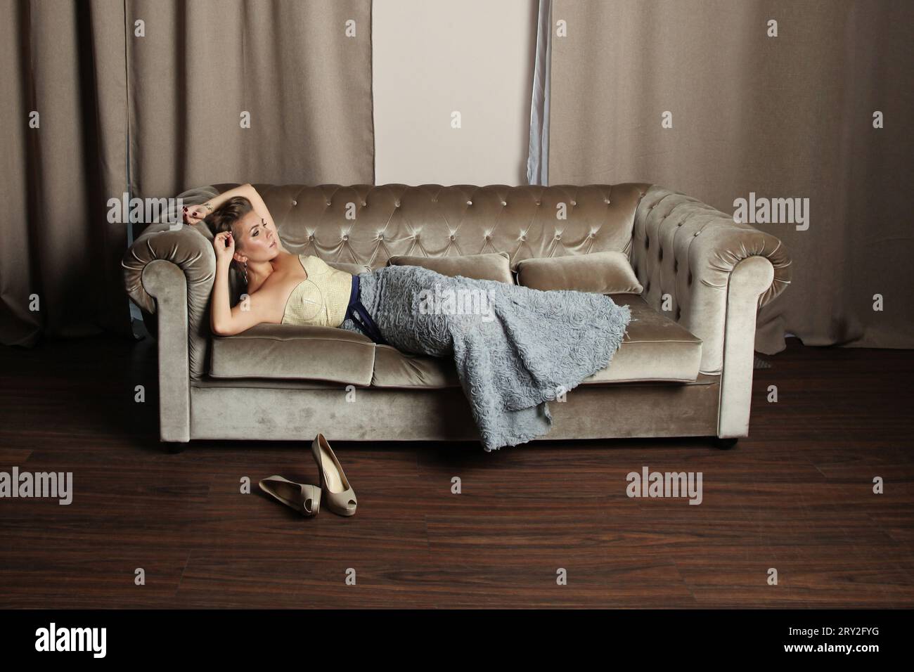 Attractive young model woman lying on sofa indoor Stock Photo - Alamy