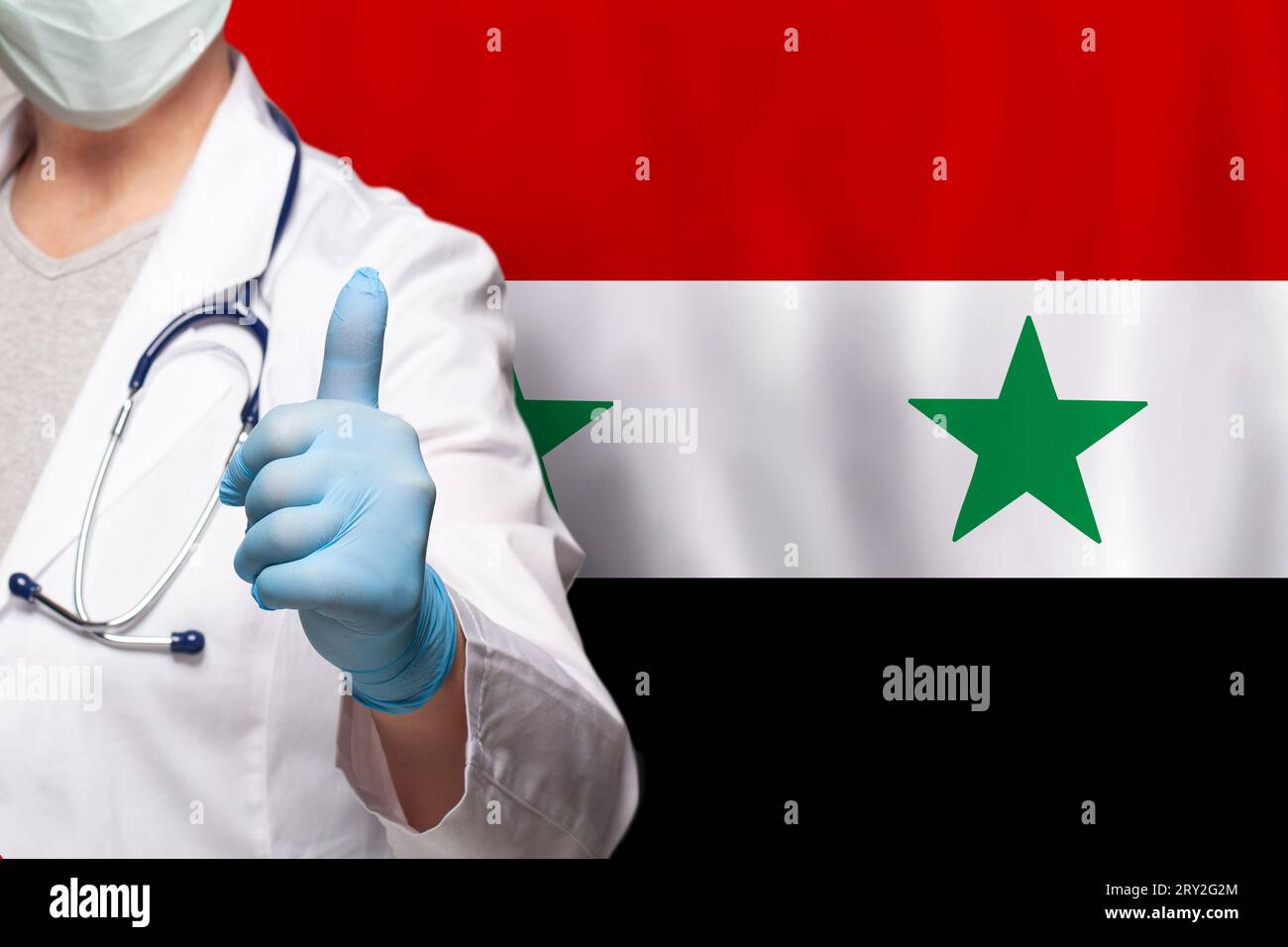 Syrian doctor's hand showing thumb up positive gesture on flag of Syria ...