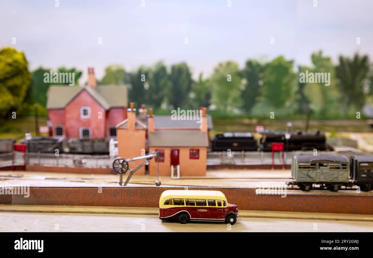 A diecast British Railways coach sits in the foreground of a scale ...