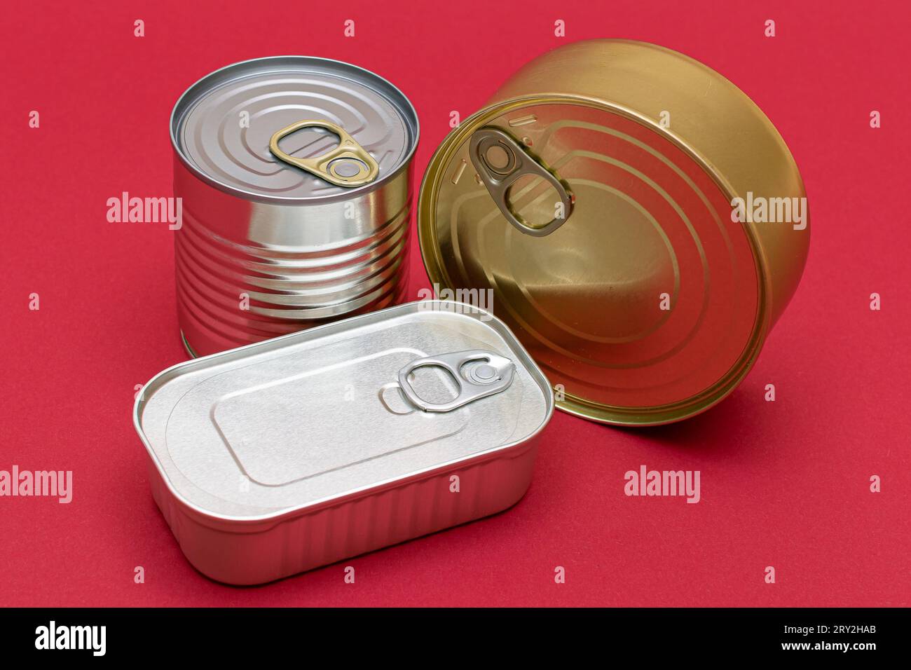 A Group of Stacked Tin Cans with Blank Edges on Red Background. Canned ...