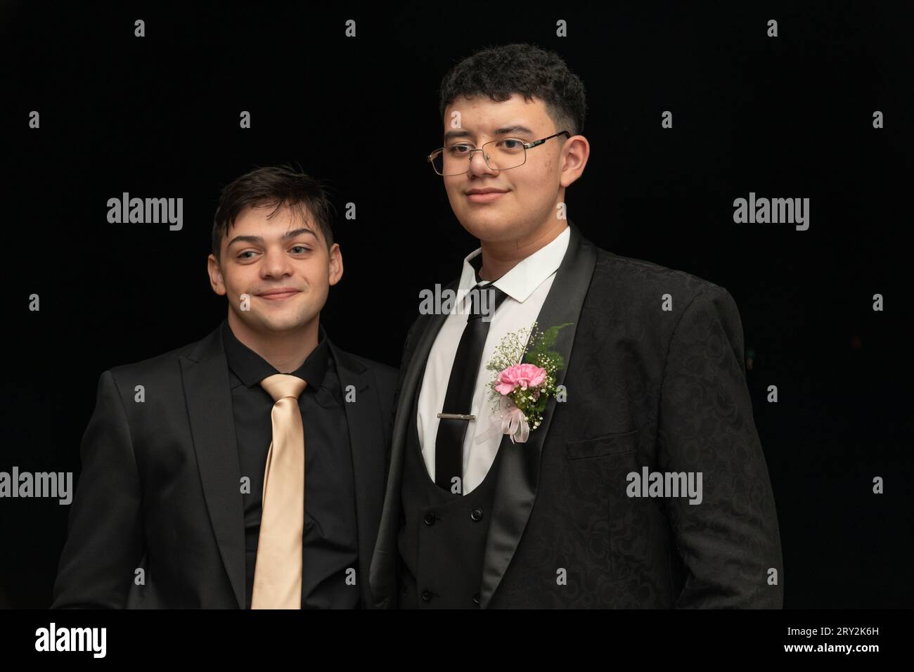 Two multiracial young men, close friends, pose casually at prom ...