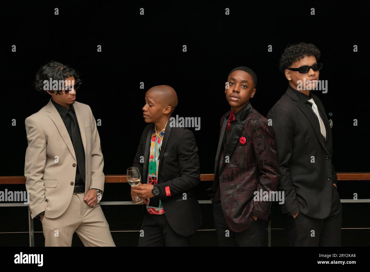 In a close-up shot, four multiracial young men at prom pose while ...