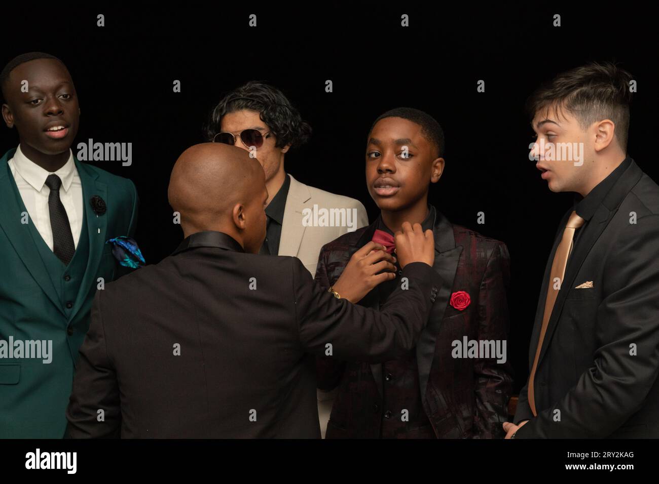In a close-up capture, five multiracial young men at prom engage in ...