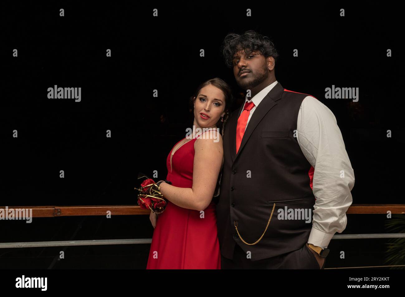 A multiracial couple in their stunning prom attire poses, radiating ...