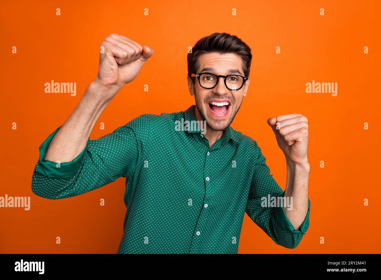 Photo of charming lucky man dressed green shirt screaming yes rising ...