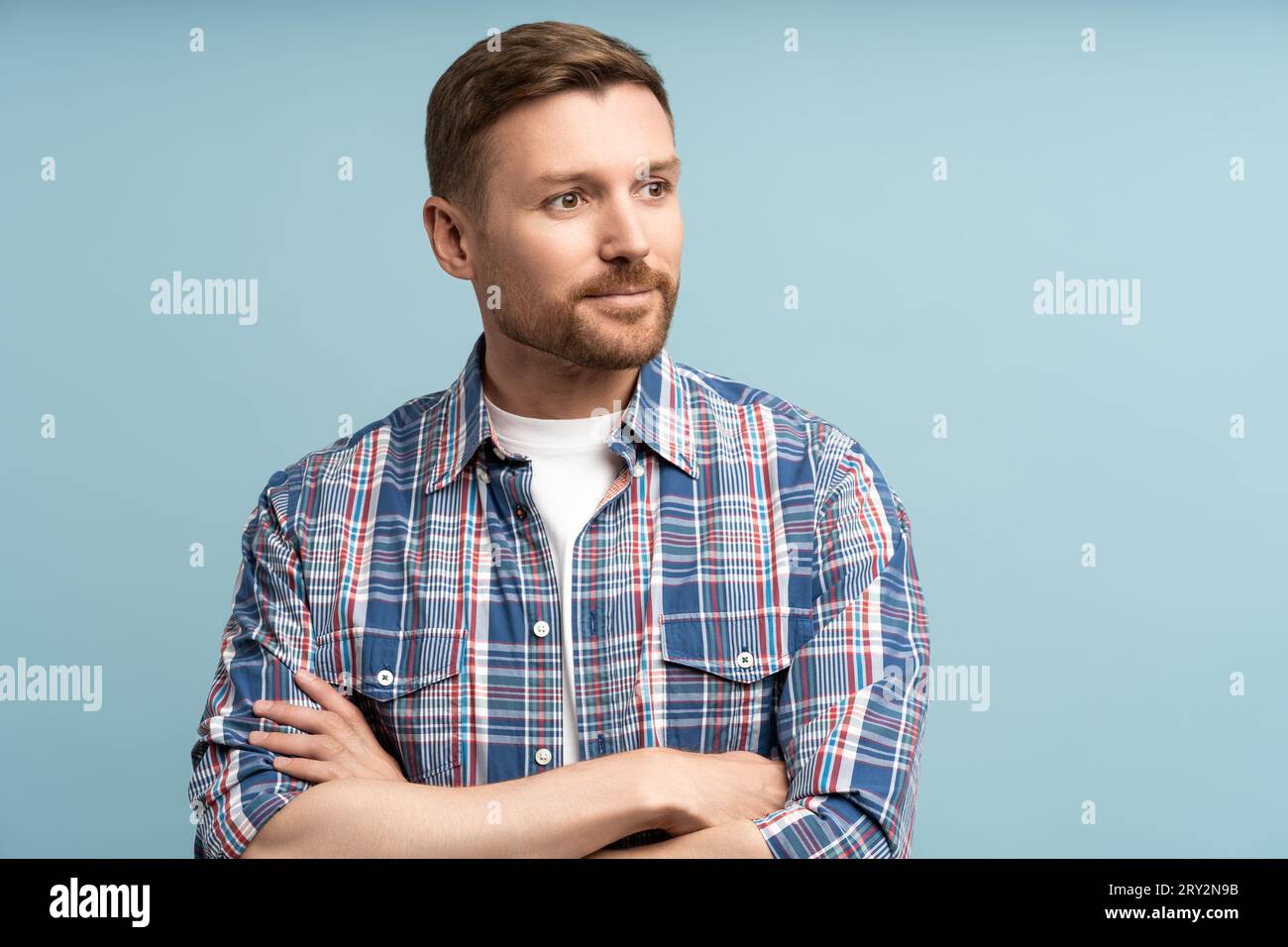 Contented satisfied guy smiles, looks away isolated background ...