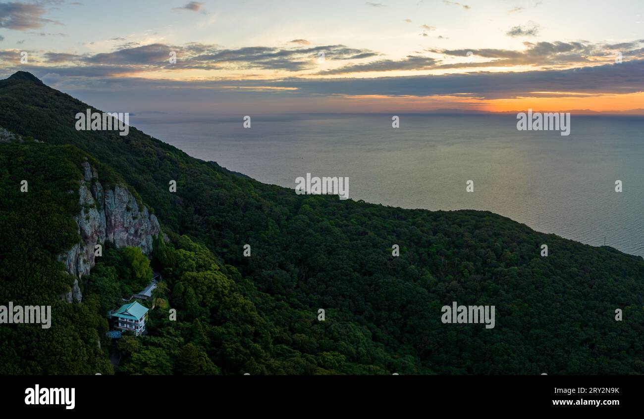 Aerial panoramic view of remote temple on mountain by sea at sunrise ...